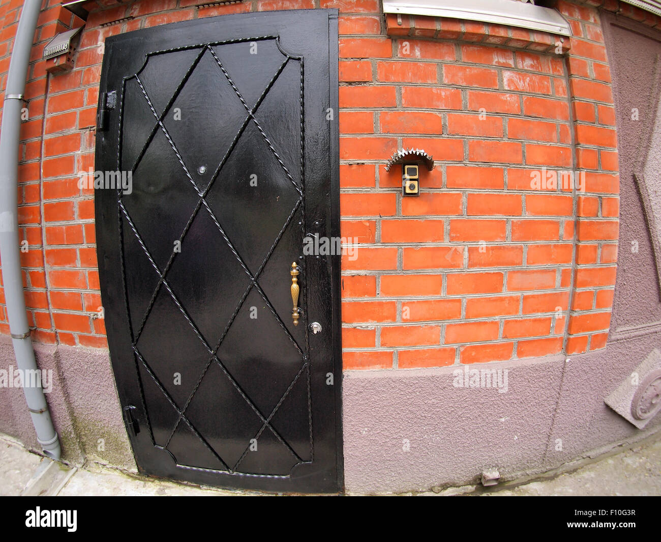 A fragment of a brick facade of the house with the door with distortion ...
