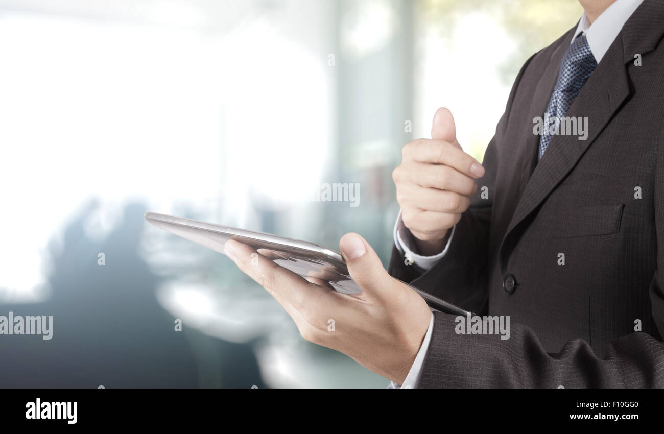 businessman hand using tablet computer and office background Stock ...