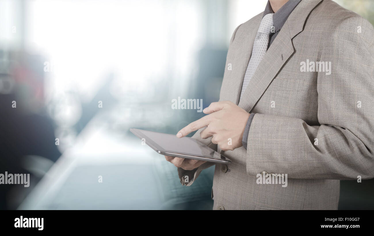 businessman hand using tablet computer and office background Stock ...