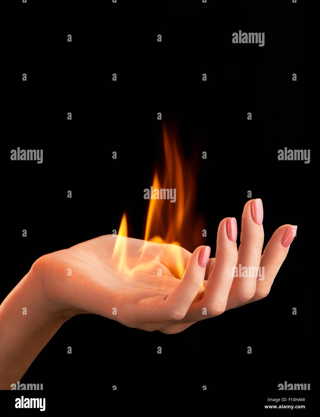 Female hand with fire inside and pink nail polish, isolated on black ...