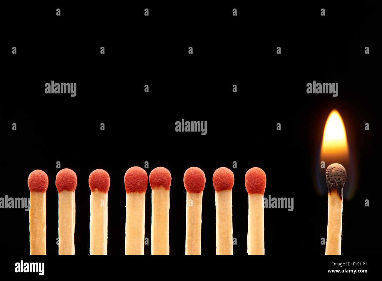 Set of eight red and one burning wooden matches isolated on black ...