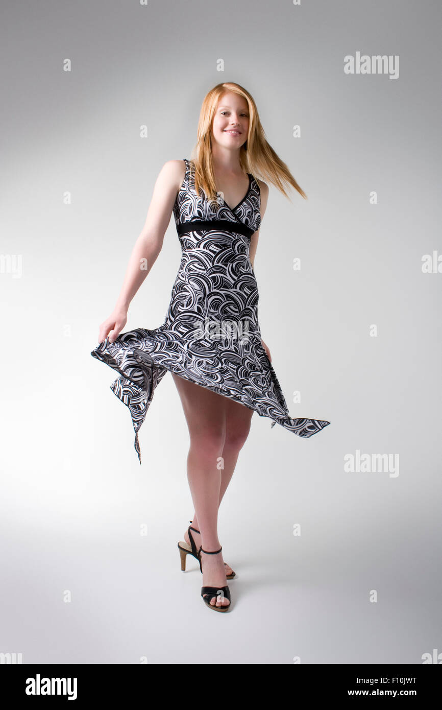 Beautiful model spinning in a studio, wearing a black and white heels ...