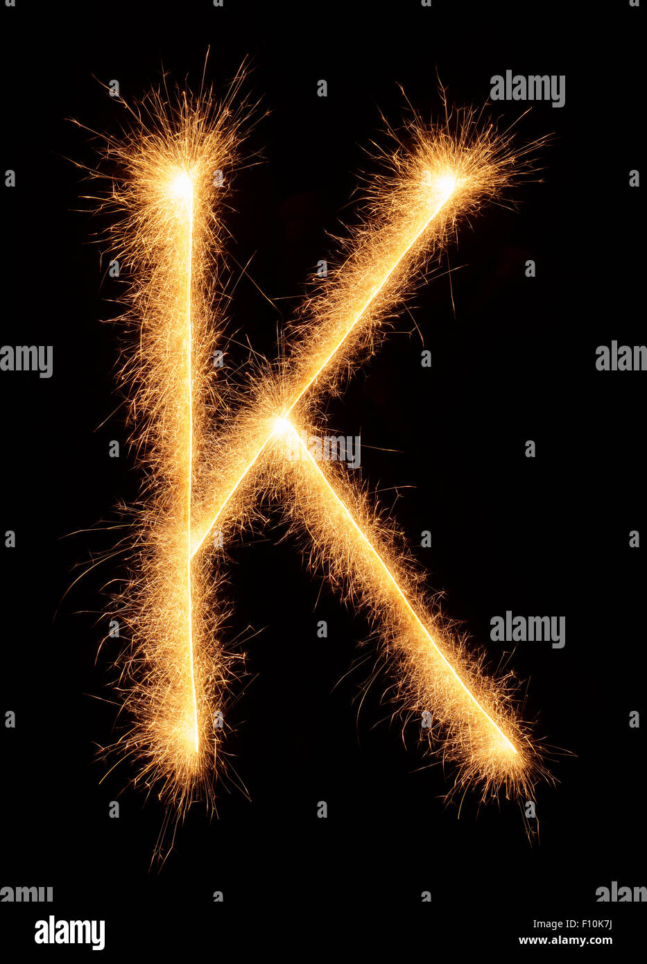 "K" letter drawn with bengali sparkles isolated on black background ...