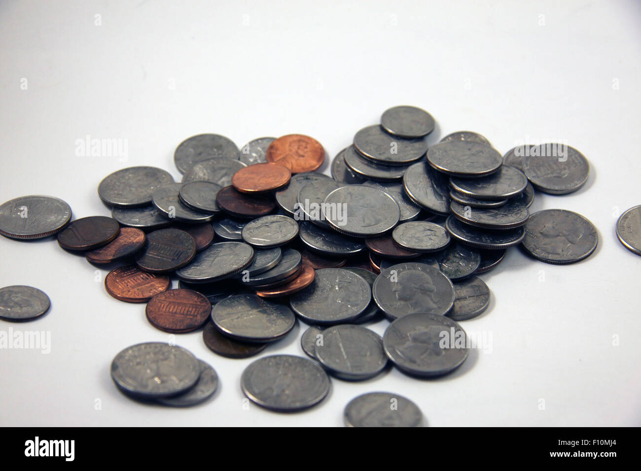 Spare change isolated against a white background Stock Photo - Alamy