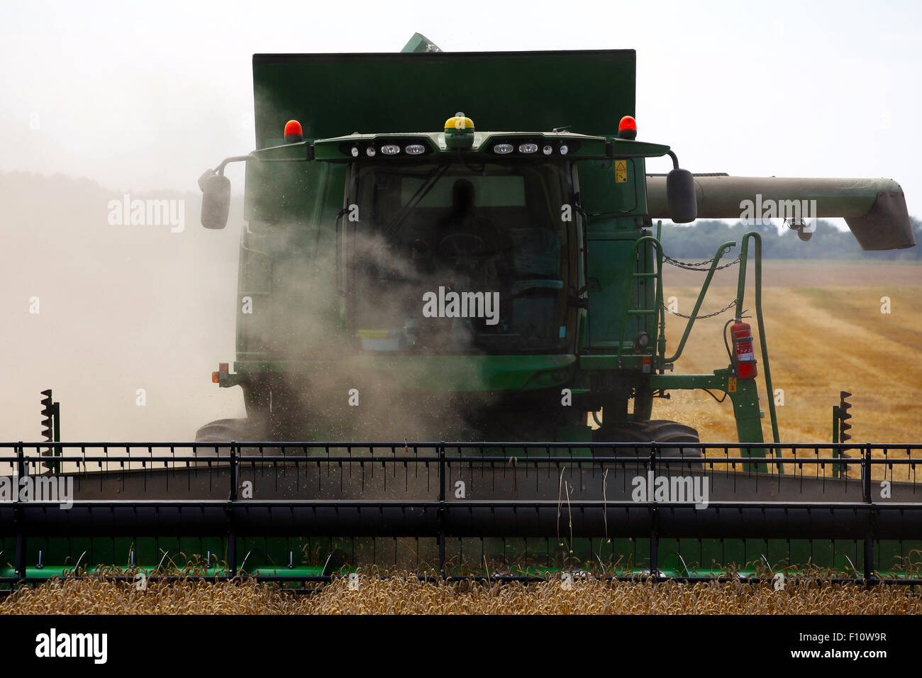 Harvester in action front view Stock Photo - Alamy
