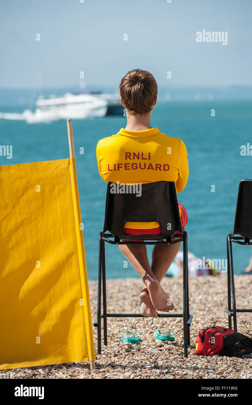 Royal Naval Lifeboat Institution lifeguard on duty on a beach in ...