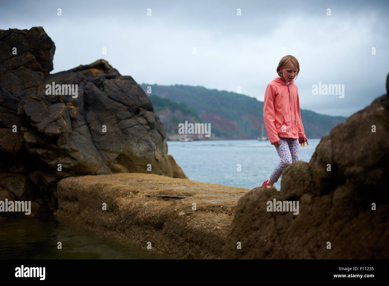 Adventurous girl playing by the sea on rocks Stock Photo - Alamy