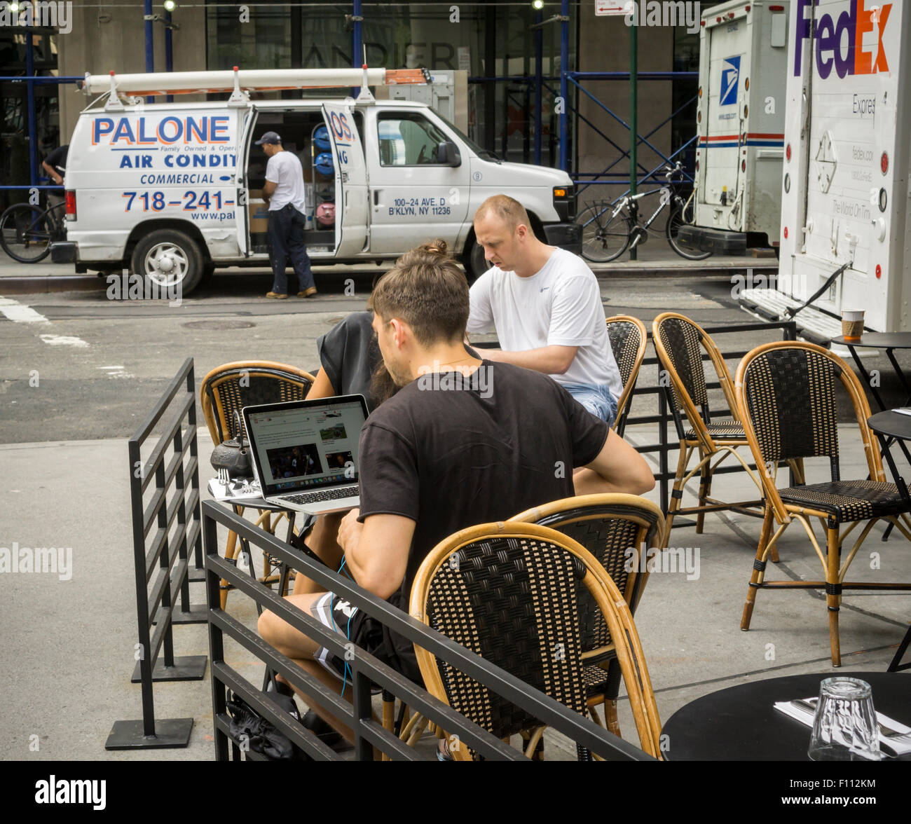 A computer user latches on to free wifi at a sidewalk cafe in the ...