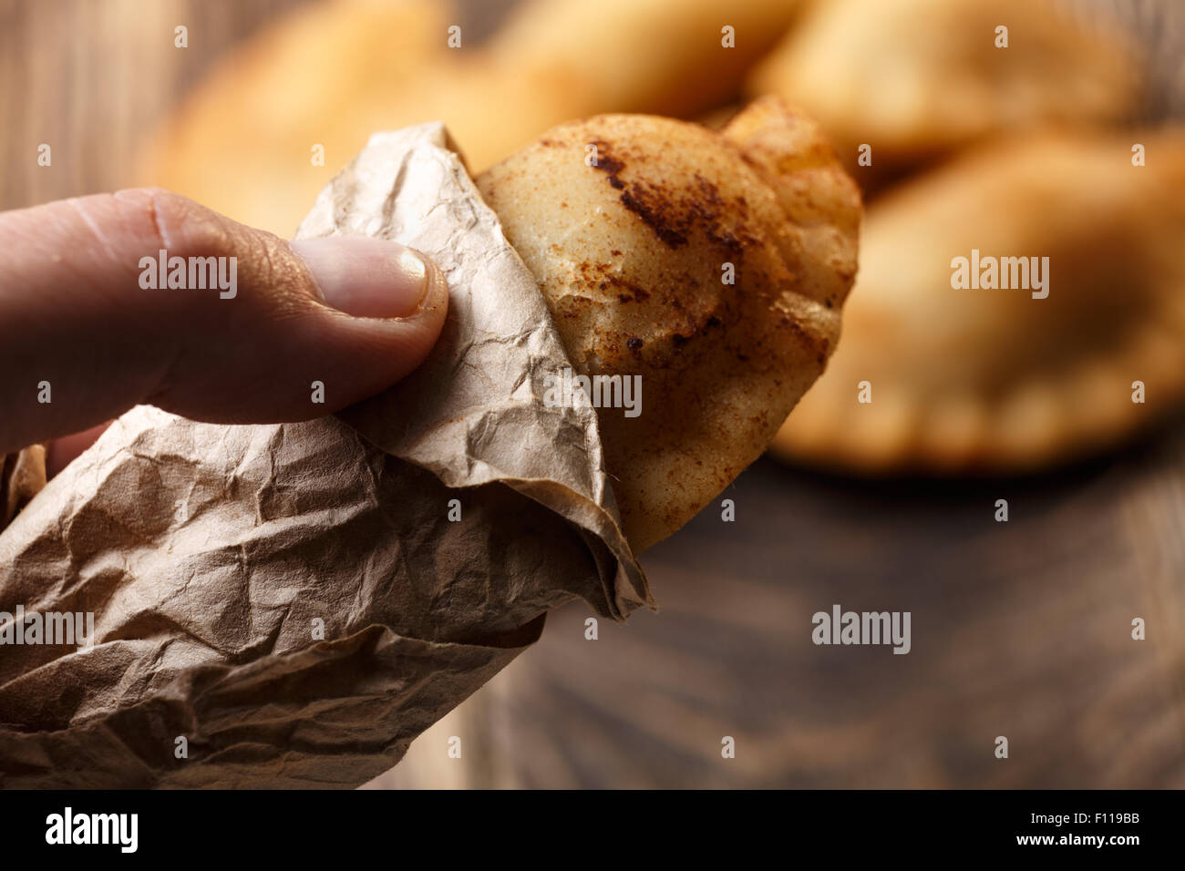 Male hand holding fried colombian empanada. Savory stuffed patties also ...