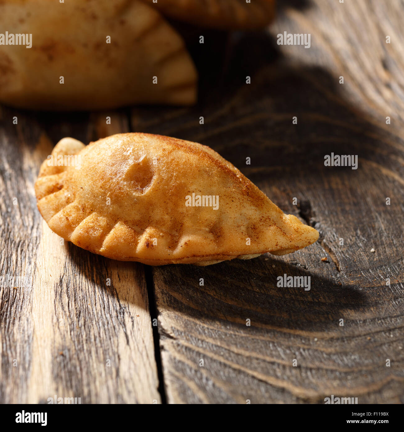 Fried colombian empanada on wooden table. Savory stuffed patty also ...