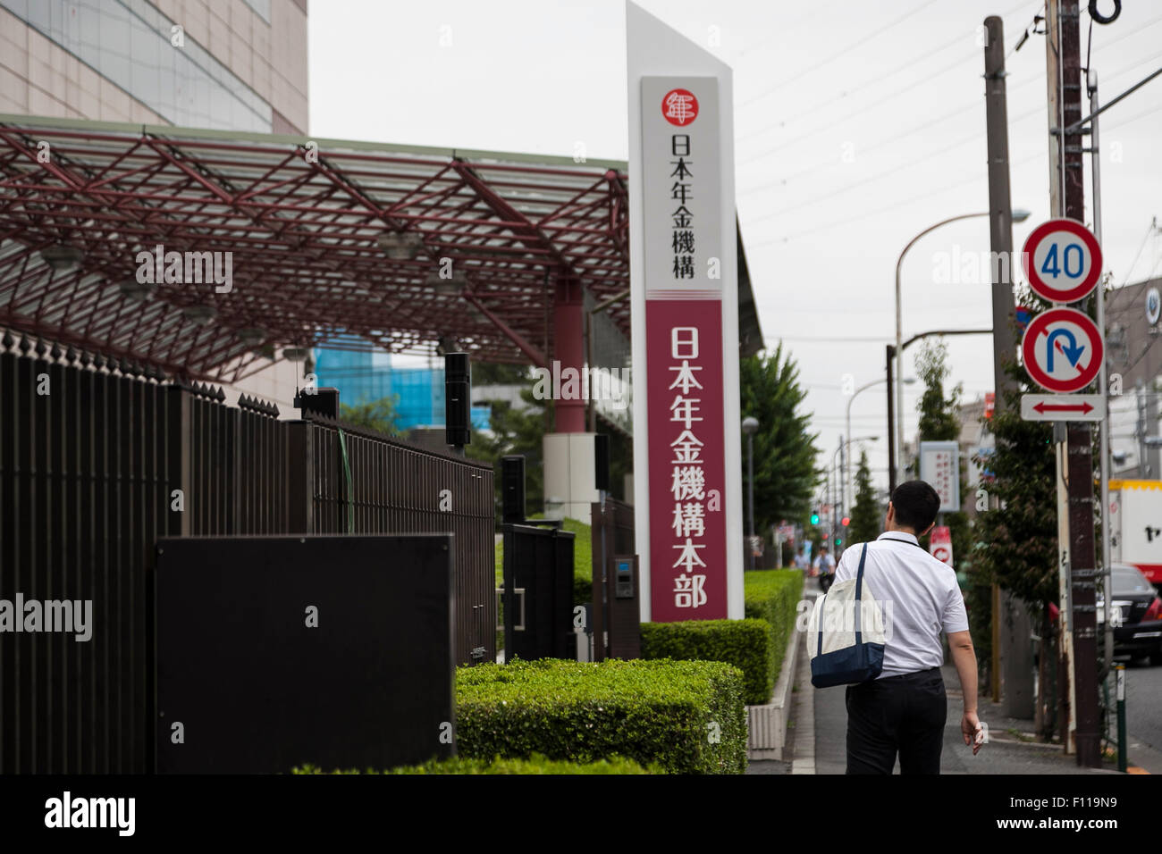 A man walks pass the Japan Pension Service (JPS) building in Tokyo ...