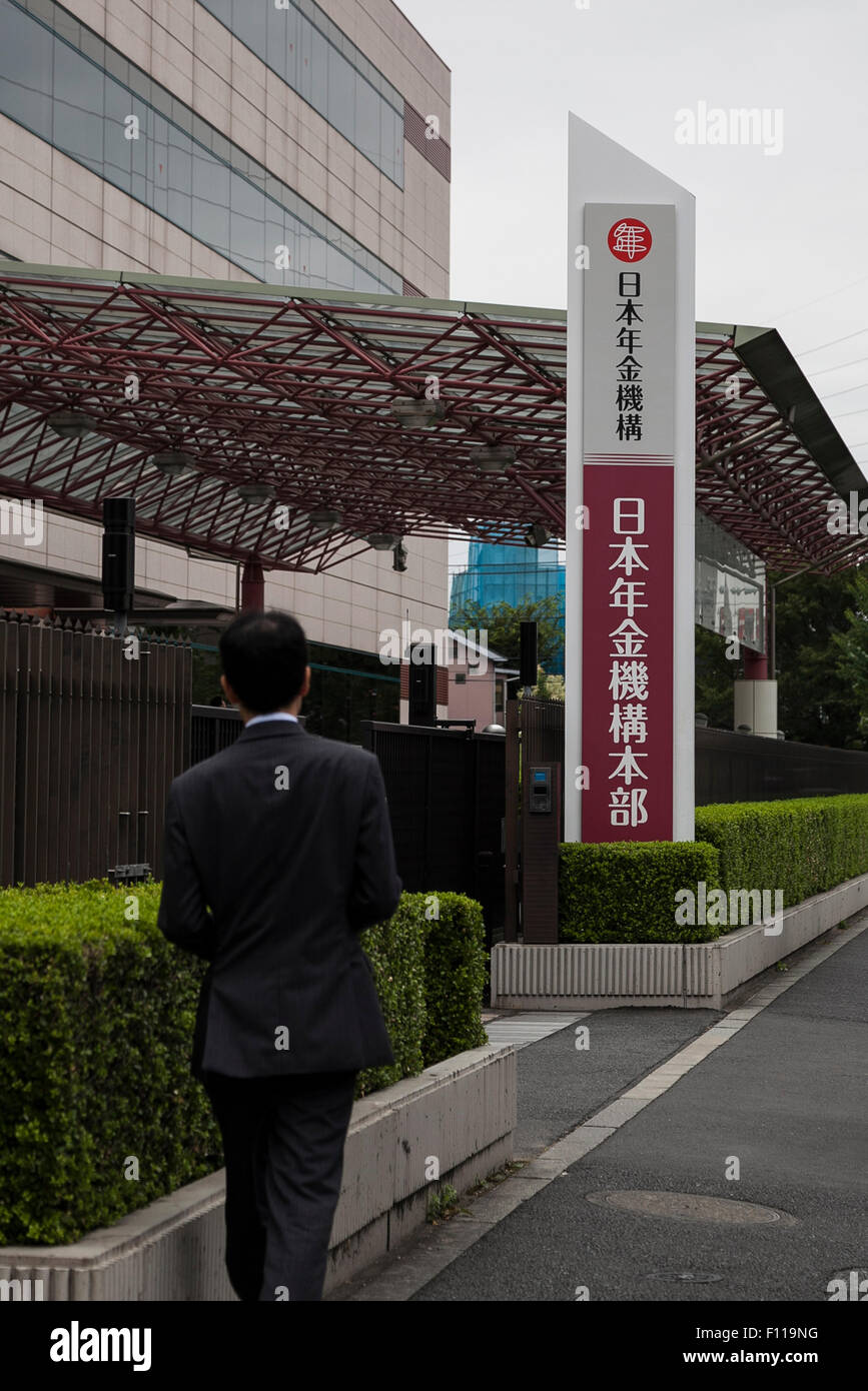 A man walks pass the Japan Pension Service (JPS) building in Tokyo ...