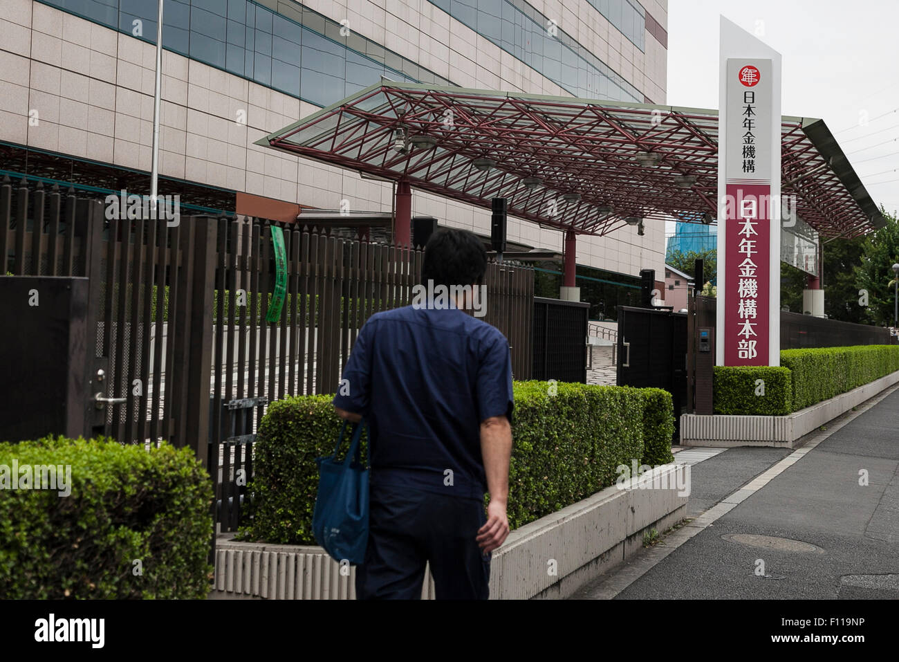 A man walks pass the Japan Pension Service (JPS) building in Tokyo ...