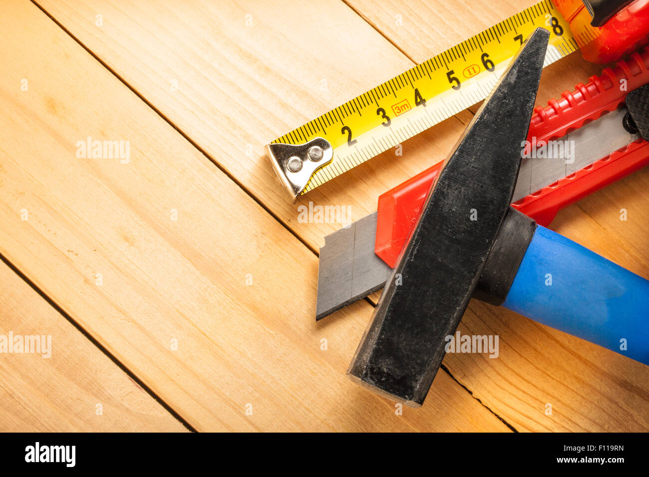 Tape measure, hammer and knife on wooden background Stock Photo - Alamy