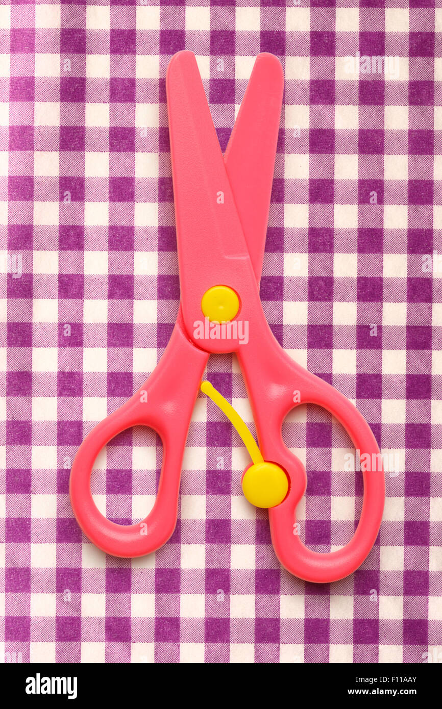 Pink safe children scissors on checked background Stock Photo - Alamy