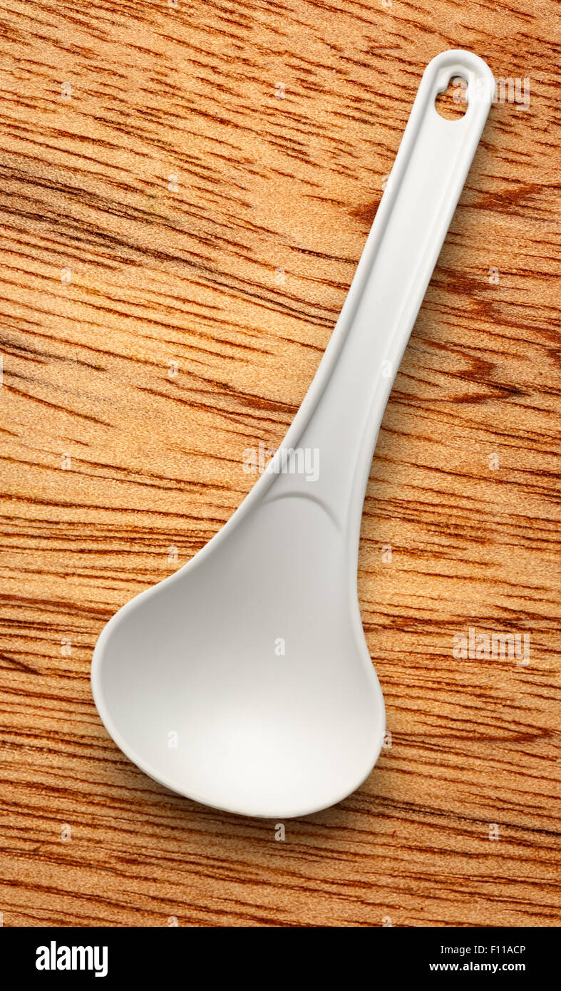 White plastic ladle on the wooden background Stock Photo - Alamy