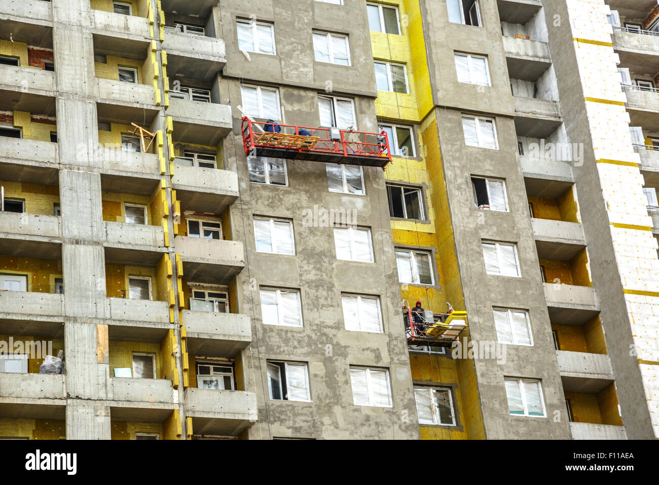 Tall building under construction and workers on platform Stock Photo ...