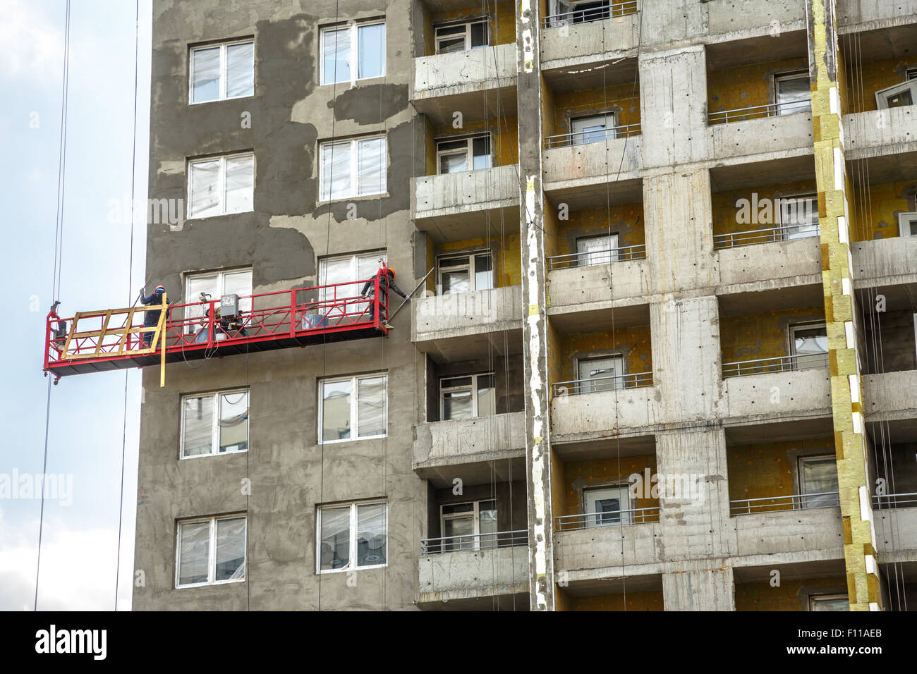 Tall building under construction and workers on platform Stock Photo ...