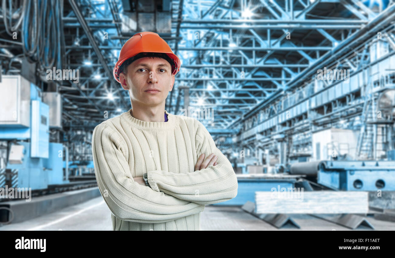 Workman in red helmet in the workshop of machinery plant Stock Photo ...