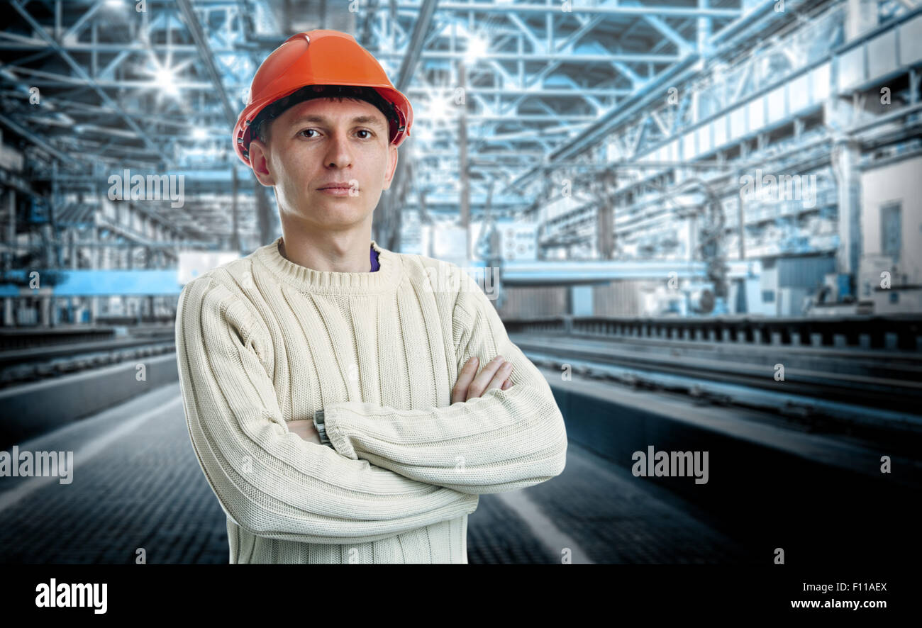 Workman in red helmet in the workshop of machinery plant Stock Photo ...