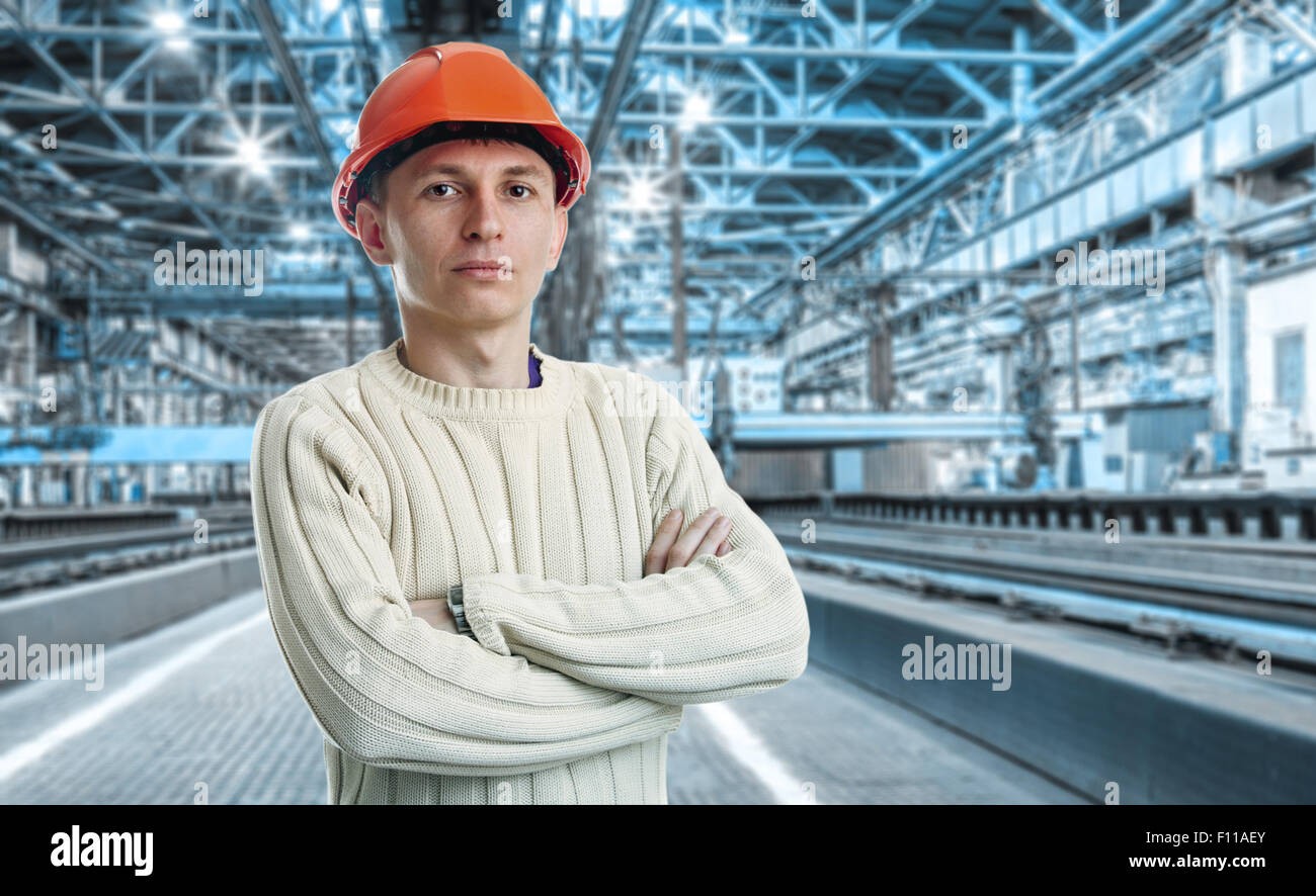 Workman in red helmet in the workshop of machinery plant Stock Photo ...
