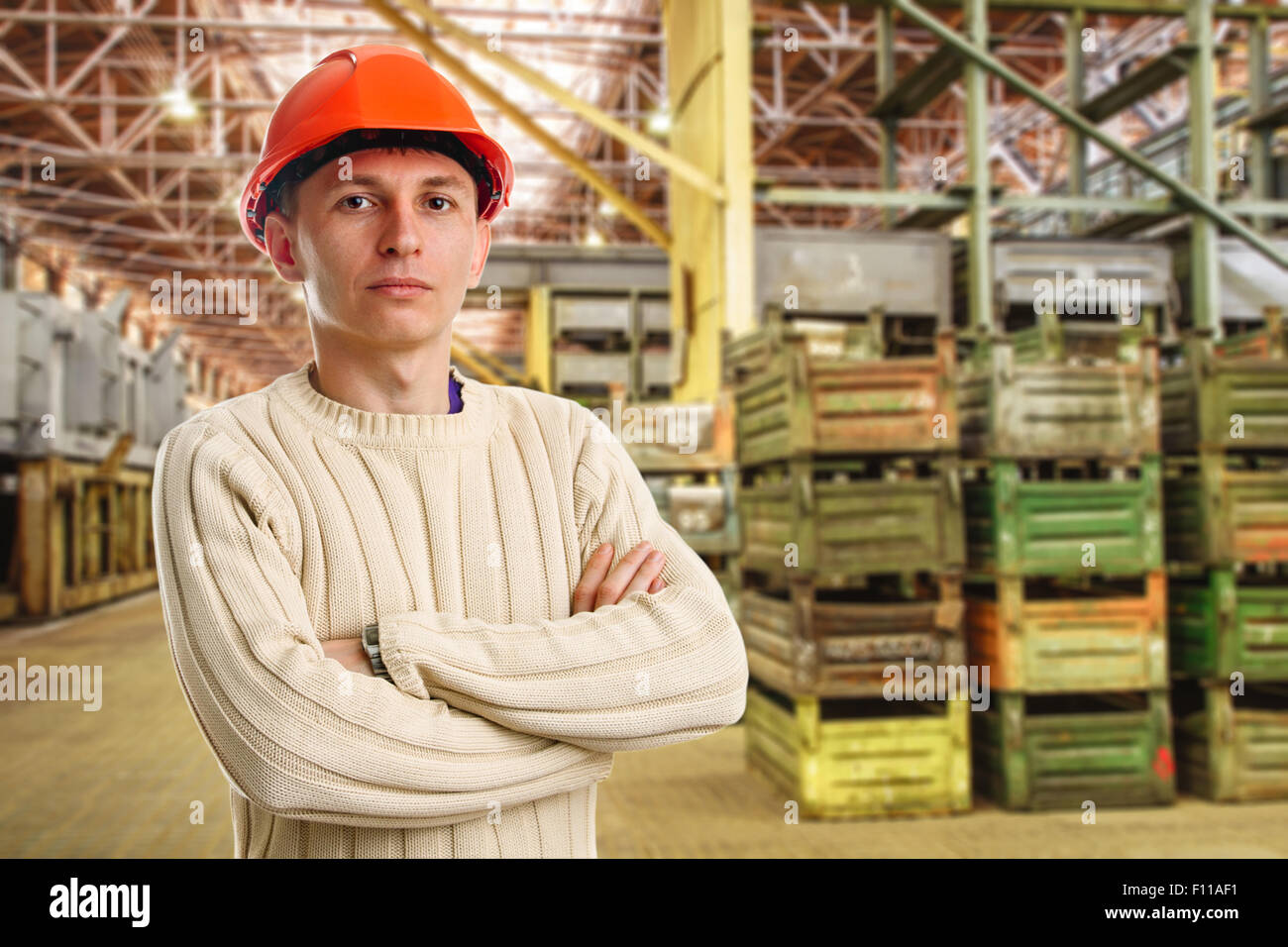 Workman in big storage room with metal boxes in factory Stock Photo - Alamy