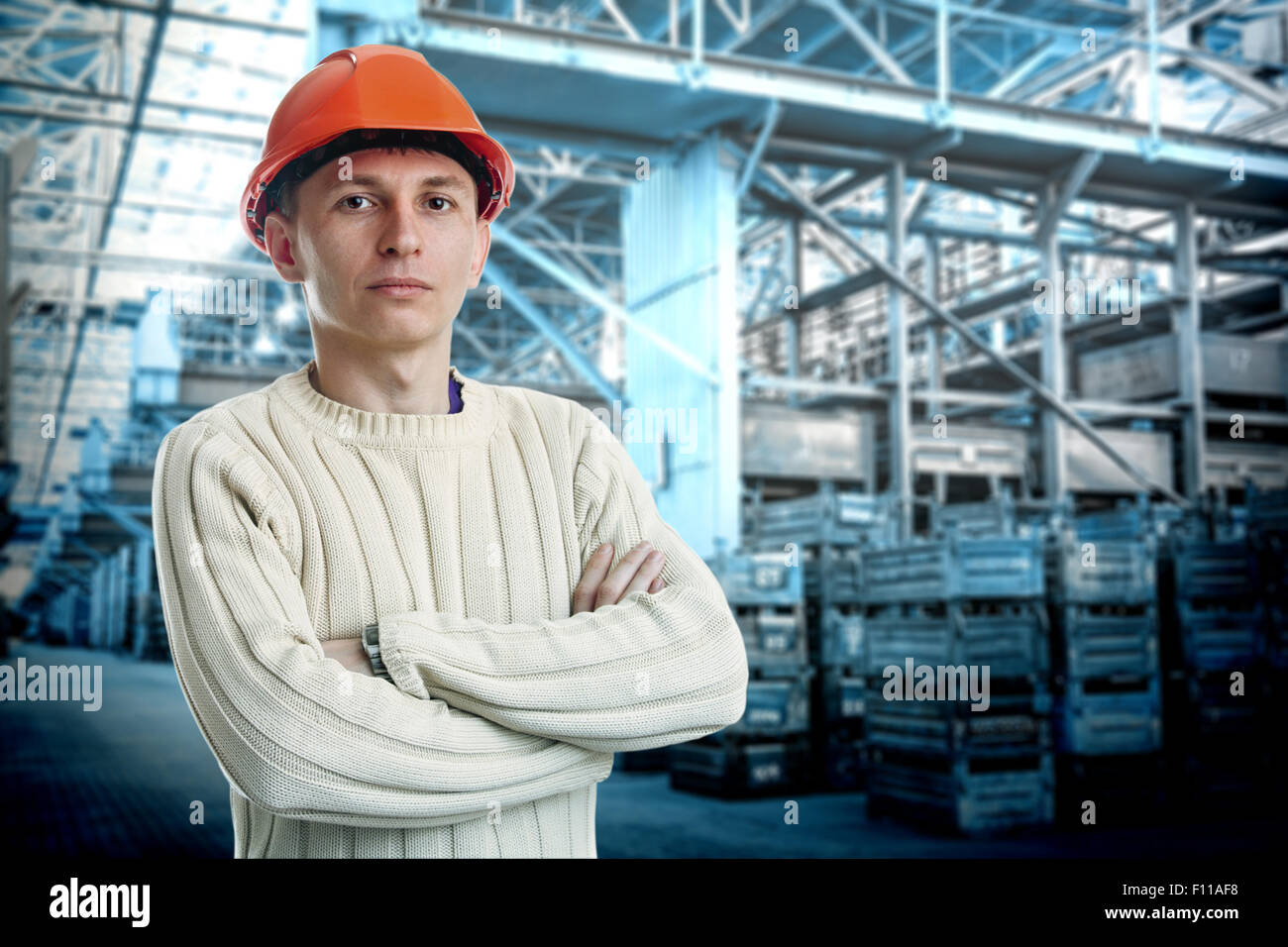 Workman in big storage room with metal boxes in factory Stock Photo - Alamy
