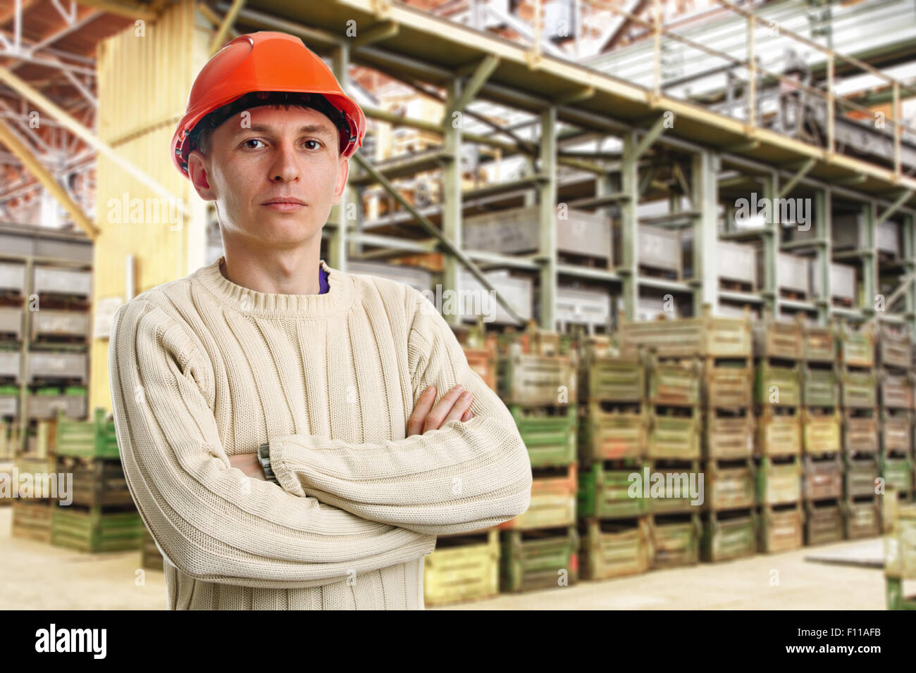 Workman in big storage room with metal boxes in factory Stock Photo - Alamy