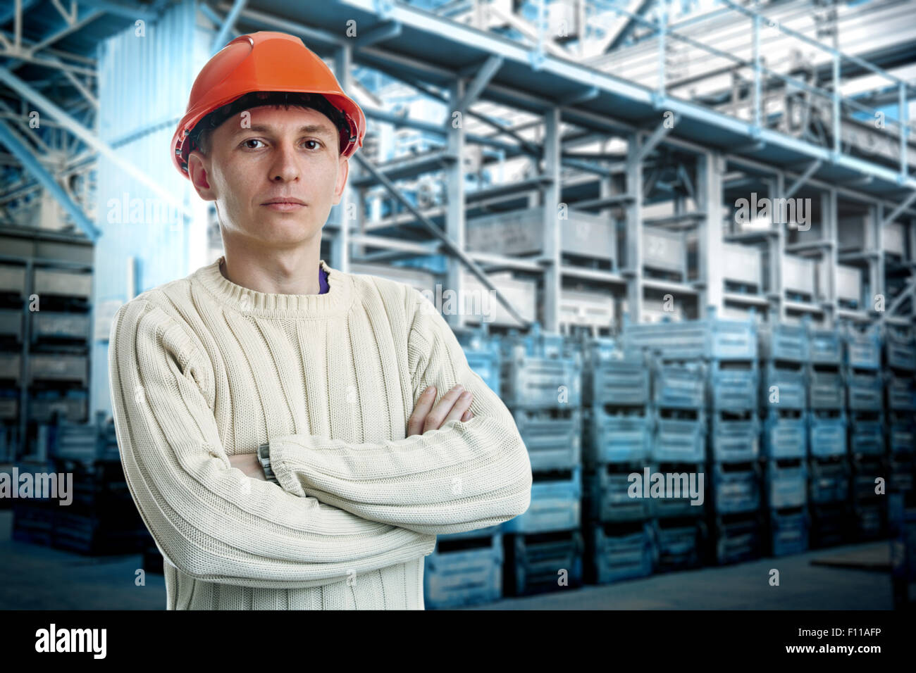 Workman in big storage room with metal boxes in factory Stock Photo - Alamy