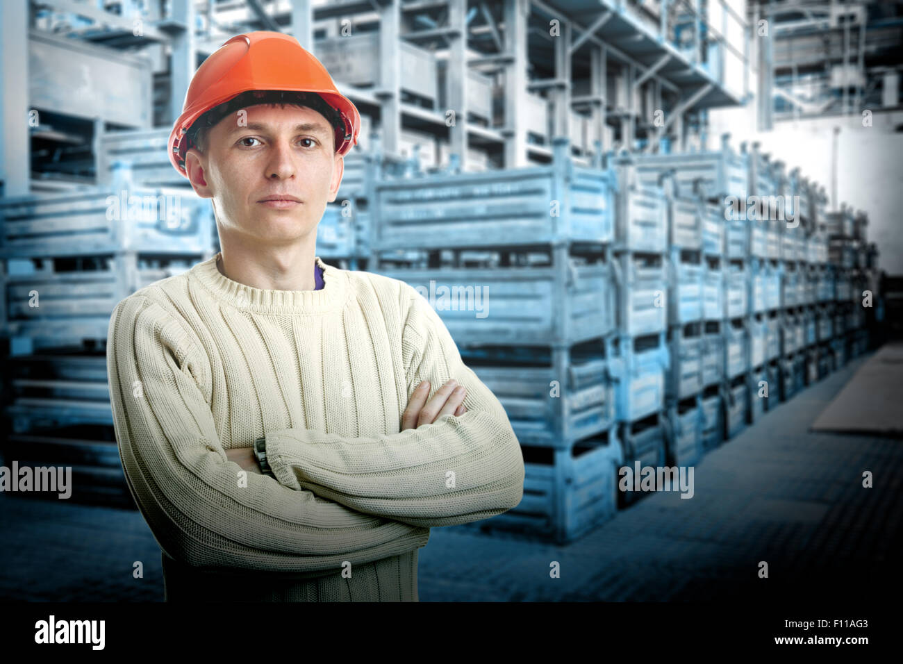 Workman in big storage room with metal boxes in factory Stock Photo - Alamy