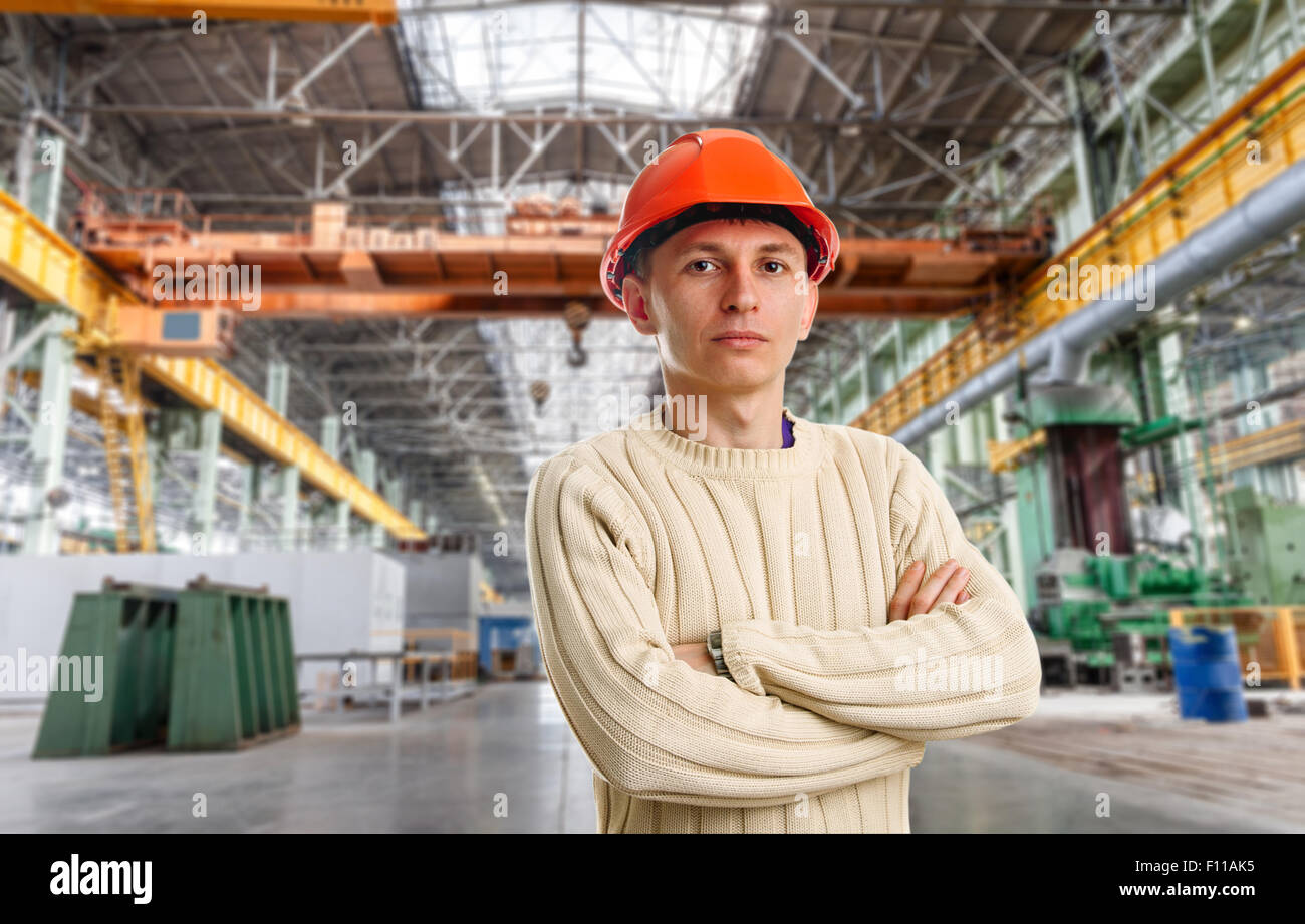 Workman in red helmet in the workshop of machinery plant Stock Photo ...