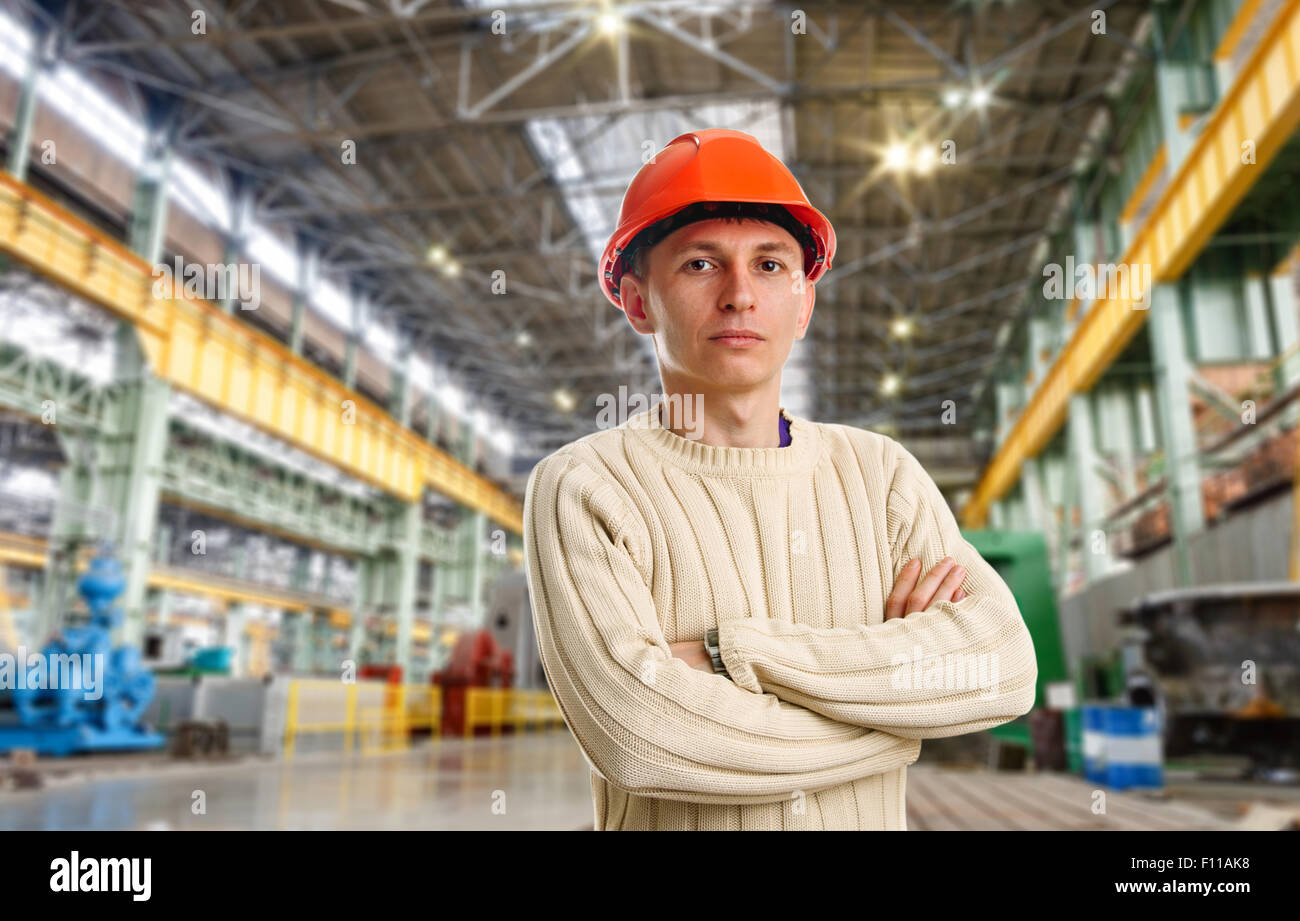 Workman in red helmet in the workshop of machinery plant Stock Photo ...