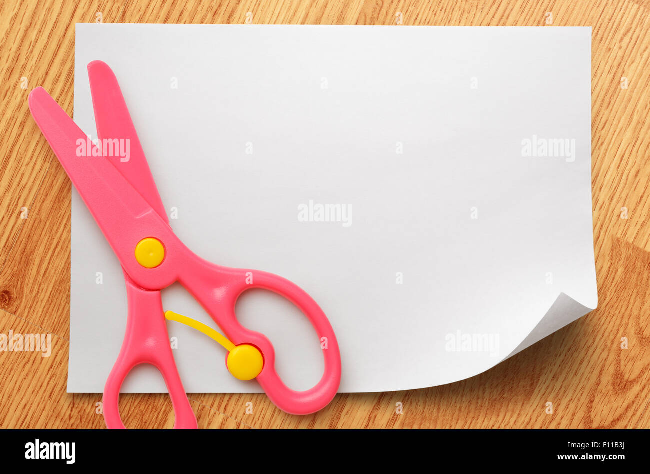 Safe scissors on blank white piece of paper Stock Photo - Alamy