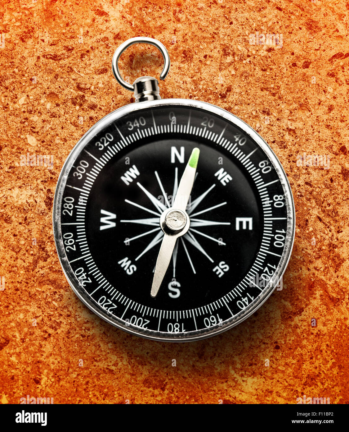 New black compass on orange in closeup Stock Photo - Alamy