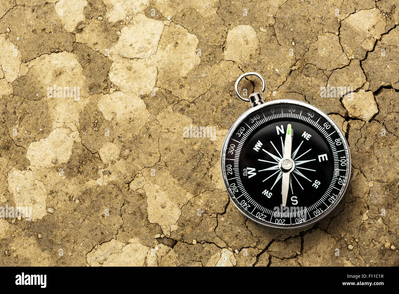 Black compass on the dry soil background Stock Photo - Alamy