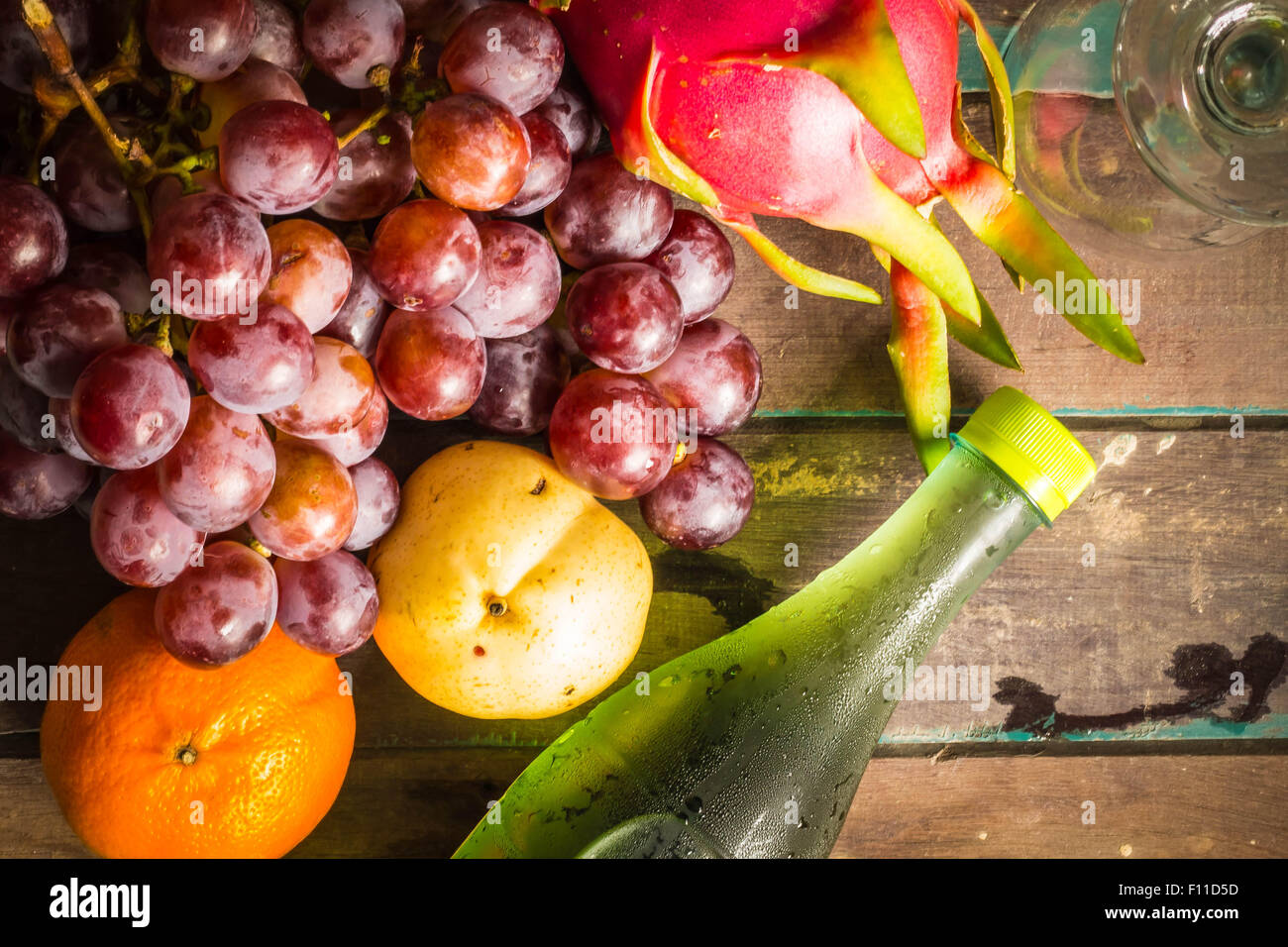 Grapes and a bottle of juice on a wooden floor Stock Photo - Alamy