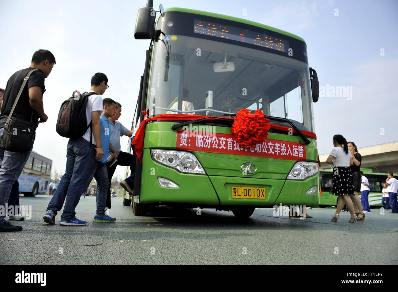 Linfen. 25th Aug, 2015. People get on an electric bus in Linfen City of ...