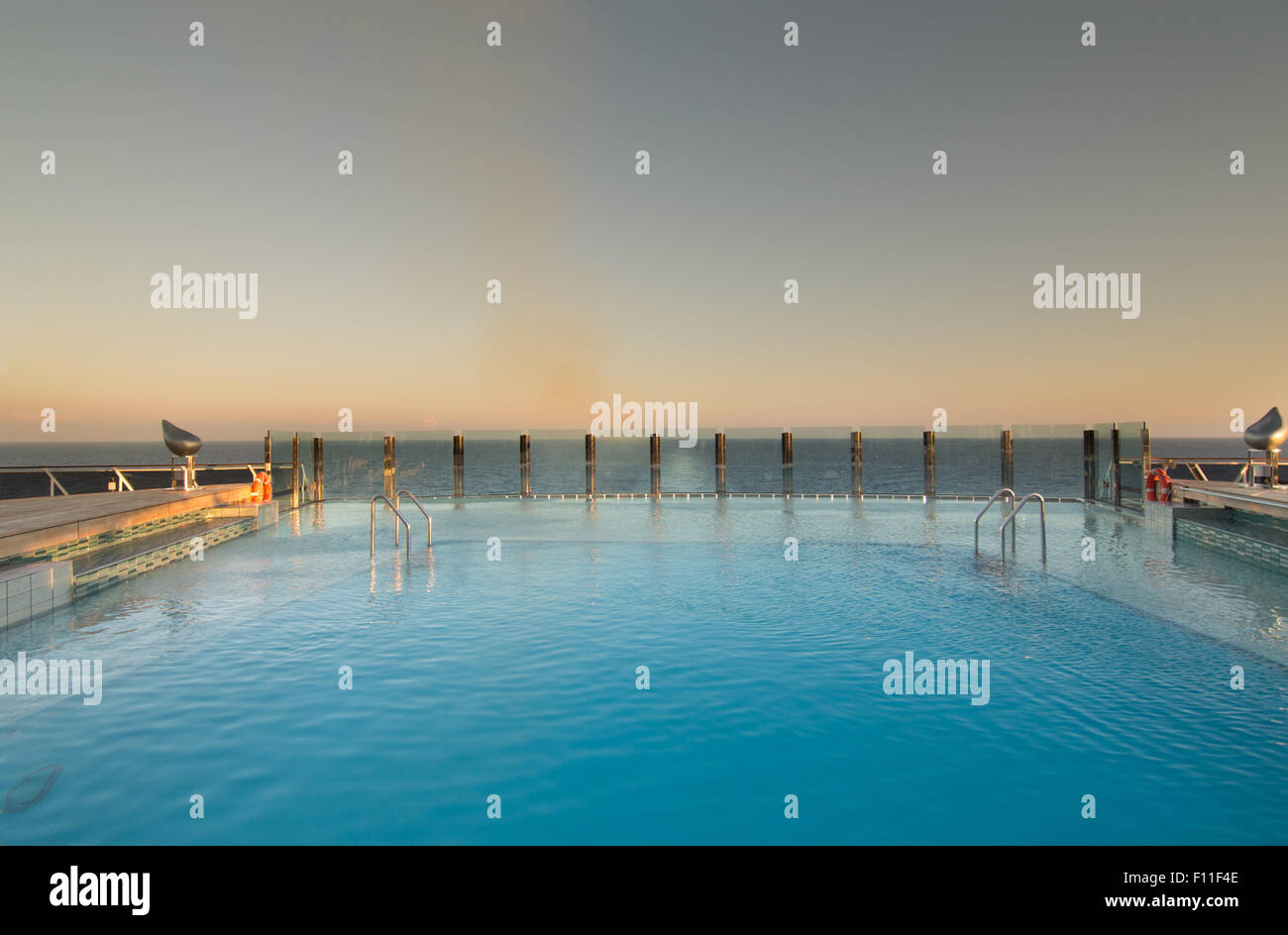 Outside pool at sunset looking over at the ocean Stock Photo - Alamy