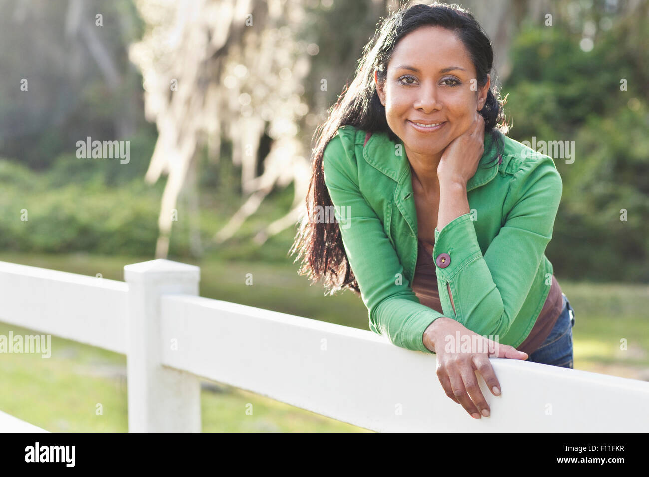Indian woman leaning on fence Stock Photo - Alamy