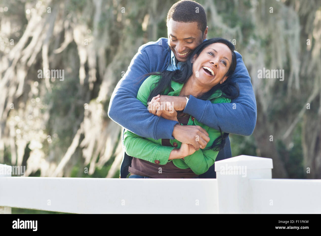 Couple hugging near fence Stock Photo - Alamy