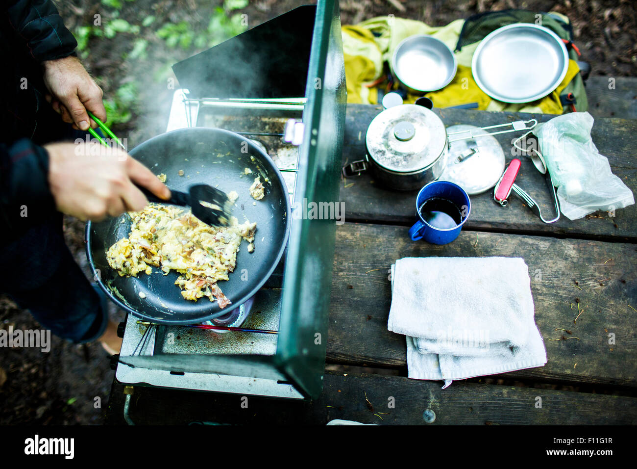 Caucasian man cooking eggs at campsite Stock Photo - Alamy