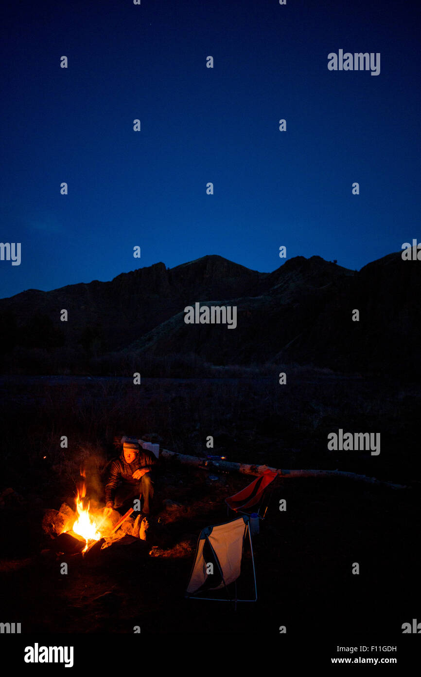 Caucasian man sitting near campfire in remote landscape Stock Photo - Alamy