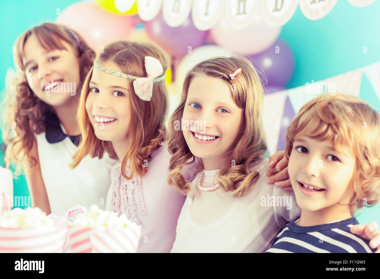 Smiling children hugging at birthday party Stock Photo - Alamy