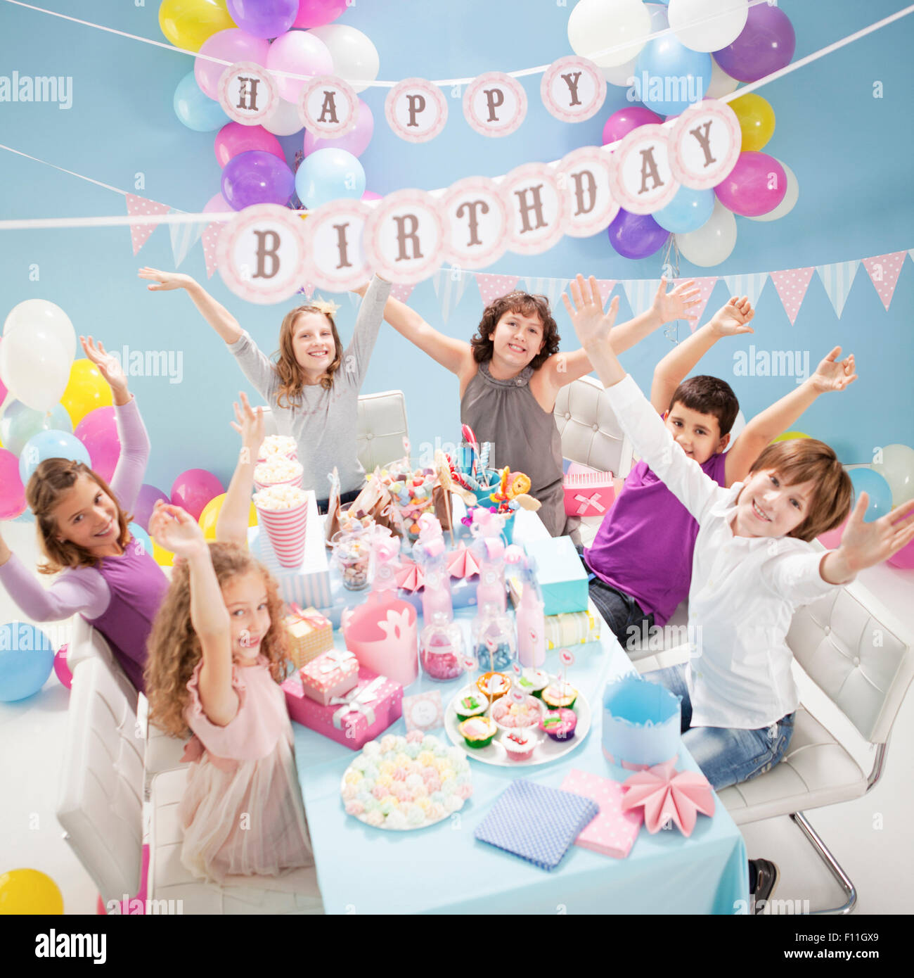 Children cheering at birthday party Stock Photo - Alamy