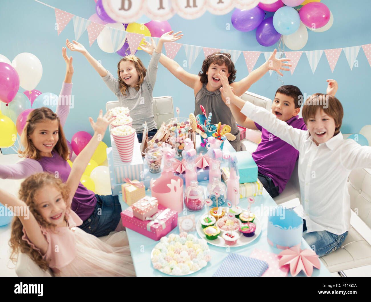Children cheering at birthday party Stock Photo - Alamy