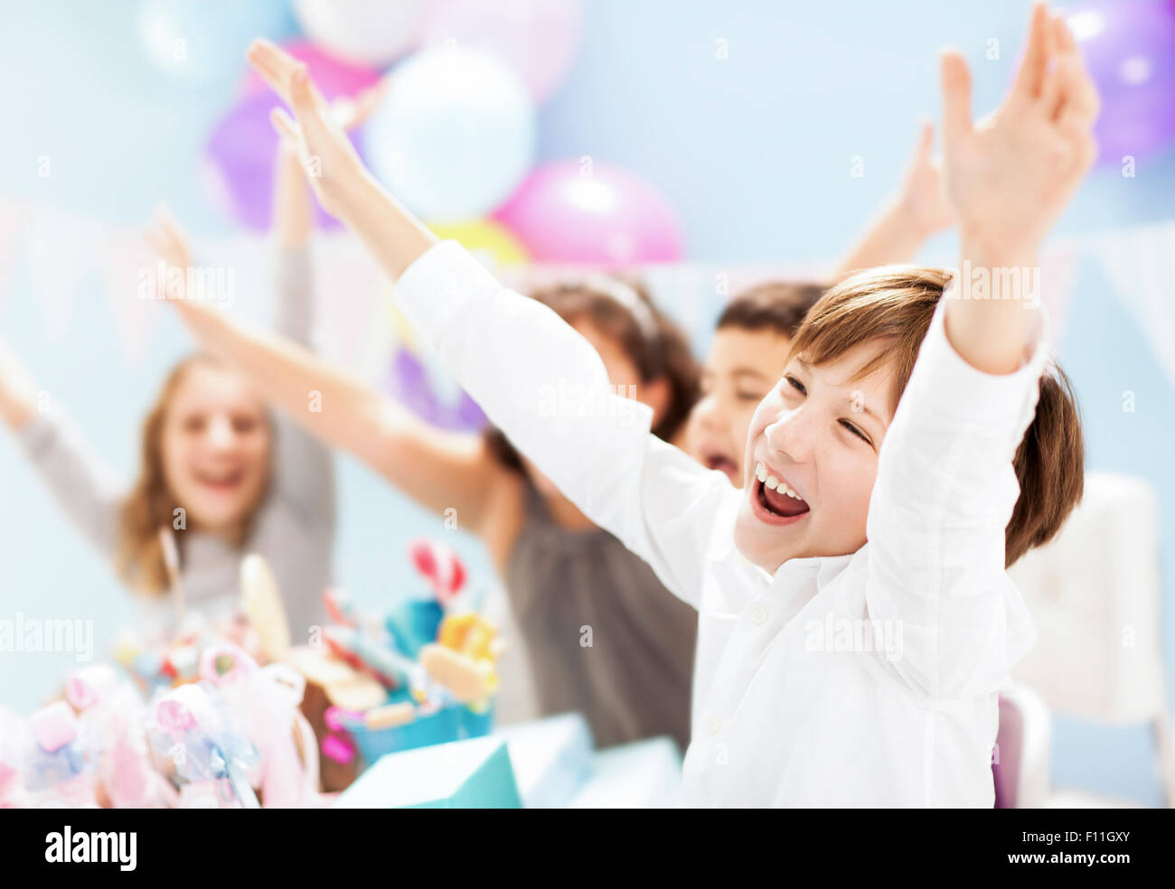 Children cheering at birthday party Stock Photo - Alamy