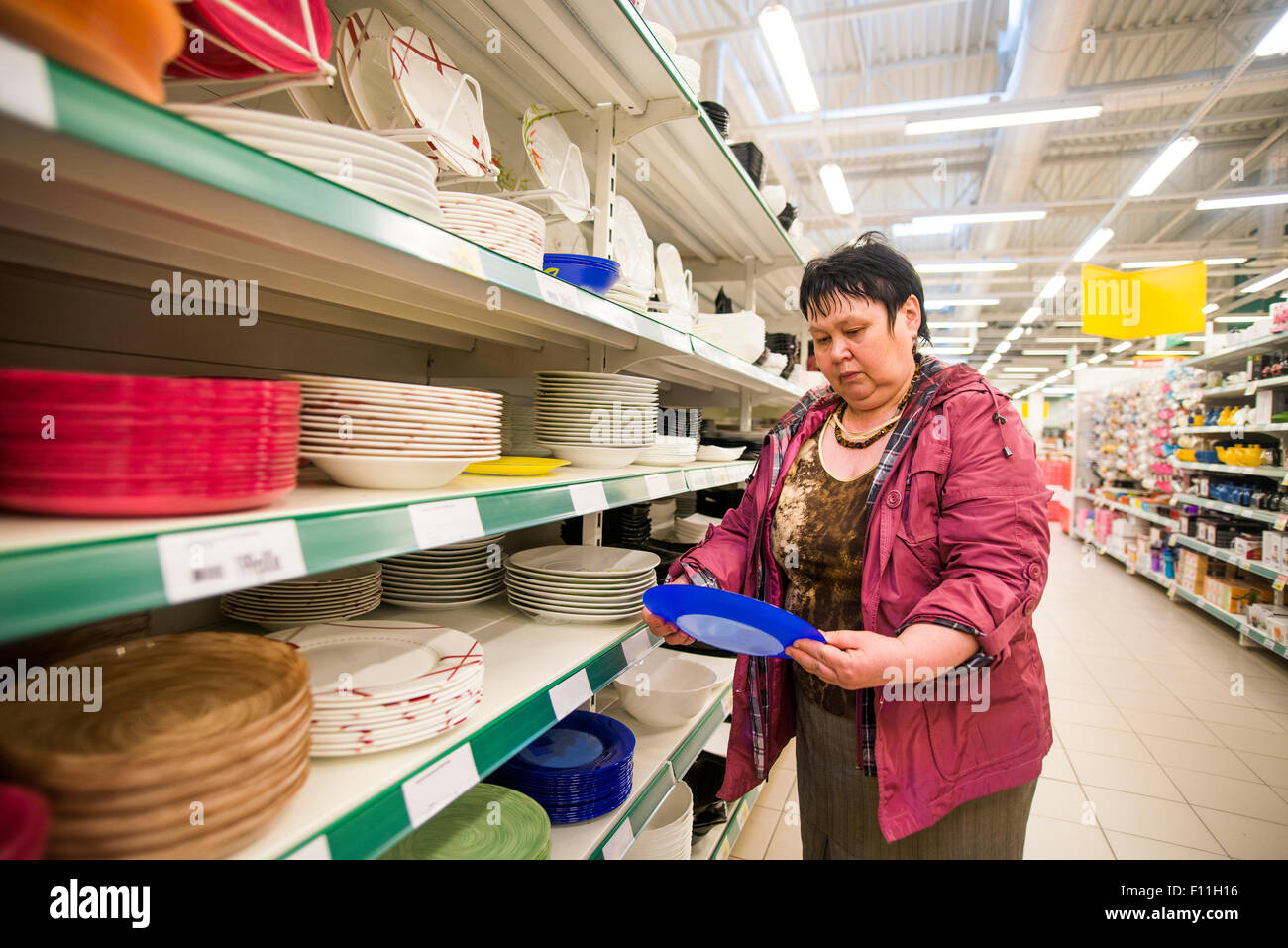 Caucasian woman shopping for dishes in store Stock Photo - Alamy