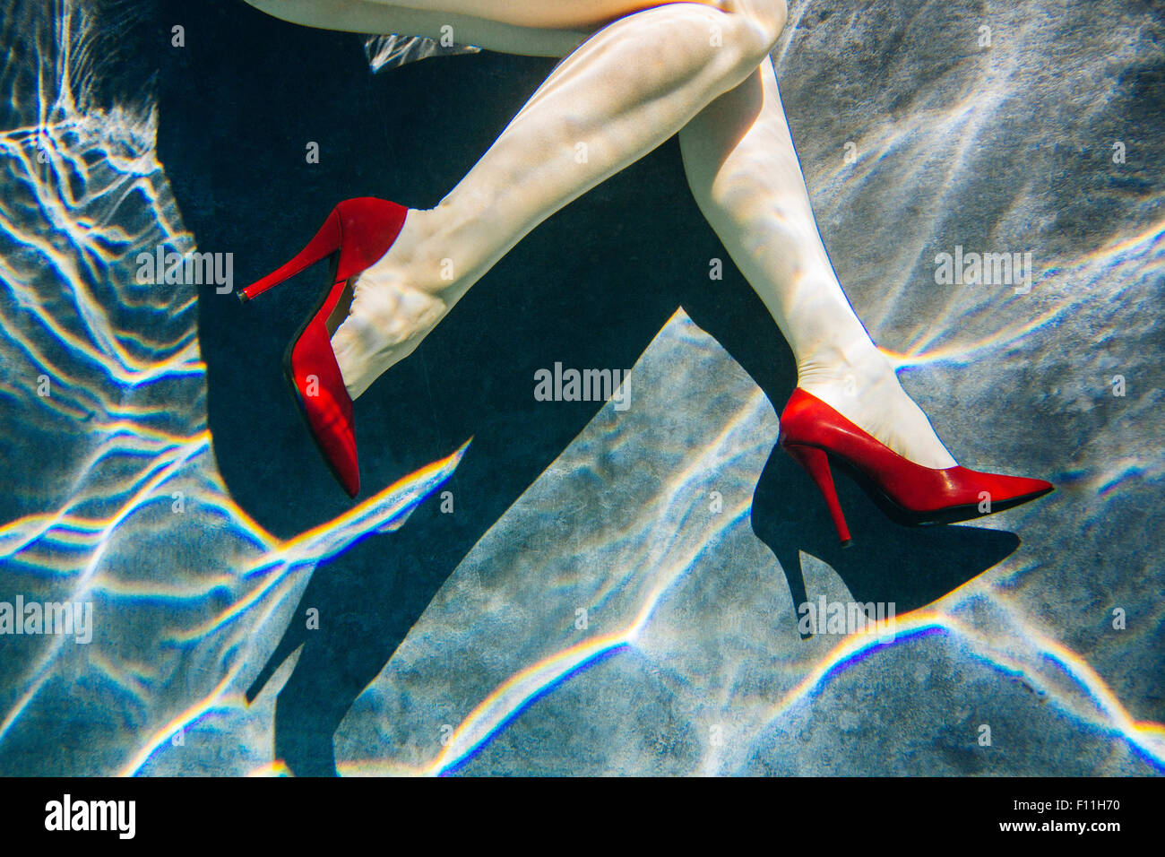 Legs of woman wearing high heels in swimming pool Stock Photo - Alamy