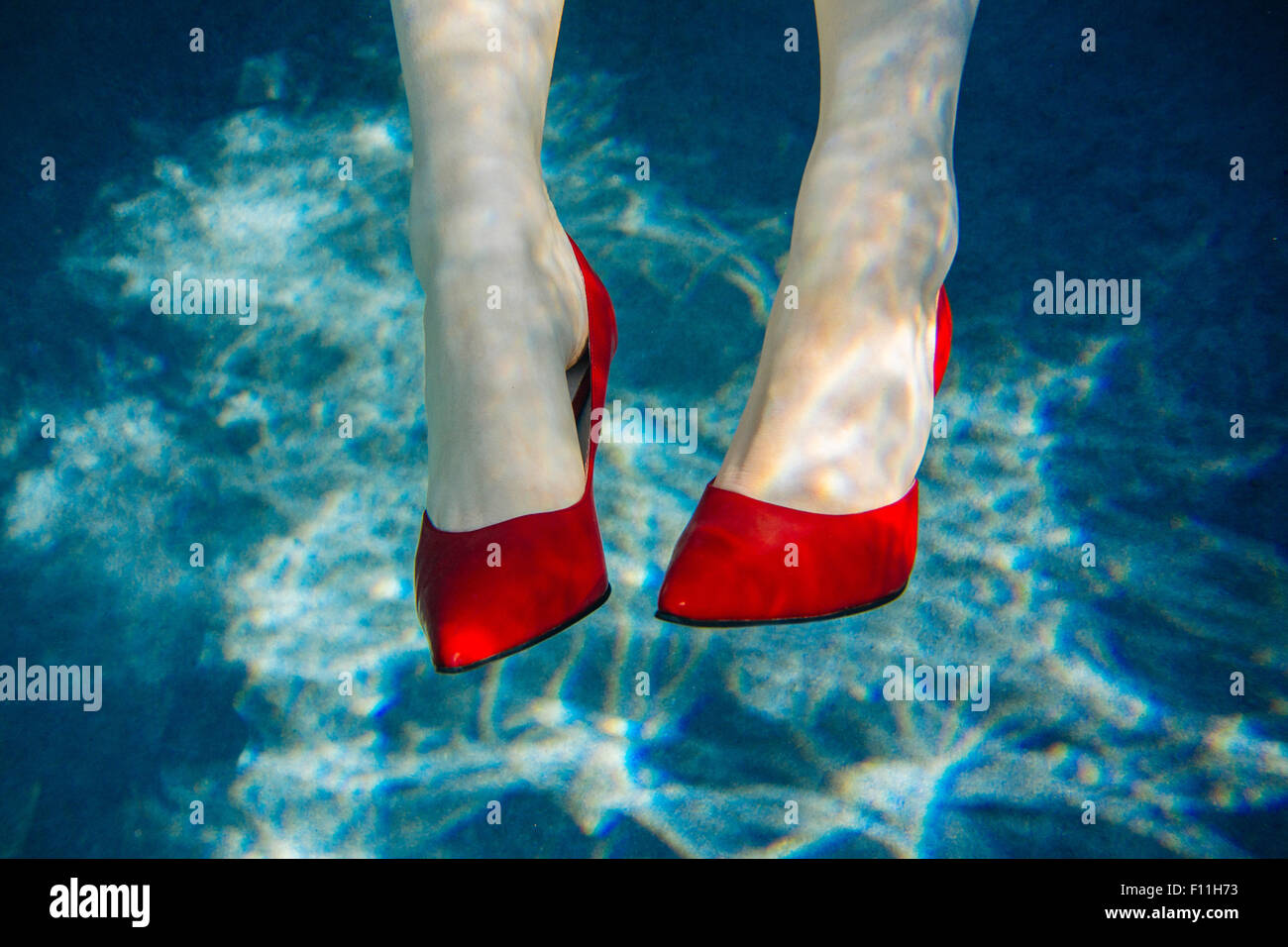 Feet of woman wearing high heels in swimming pool Stock Photo - Alamy