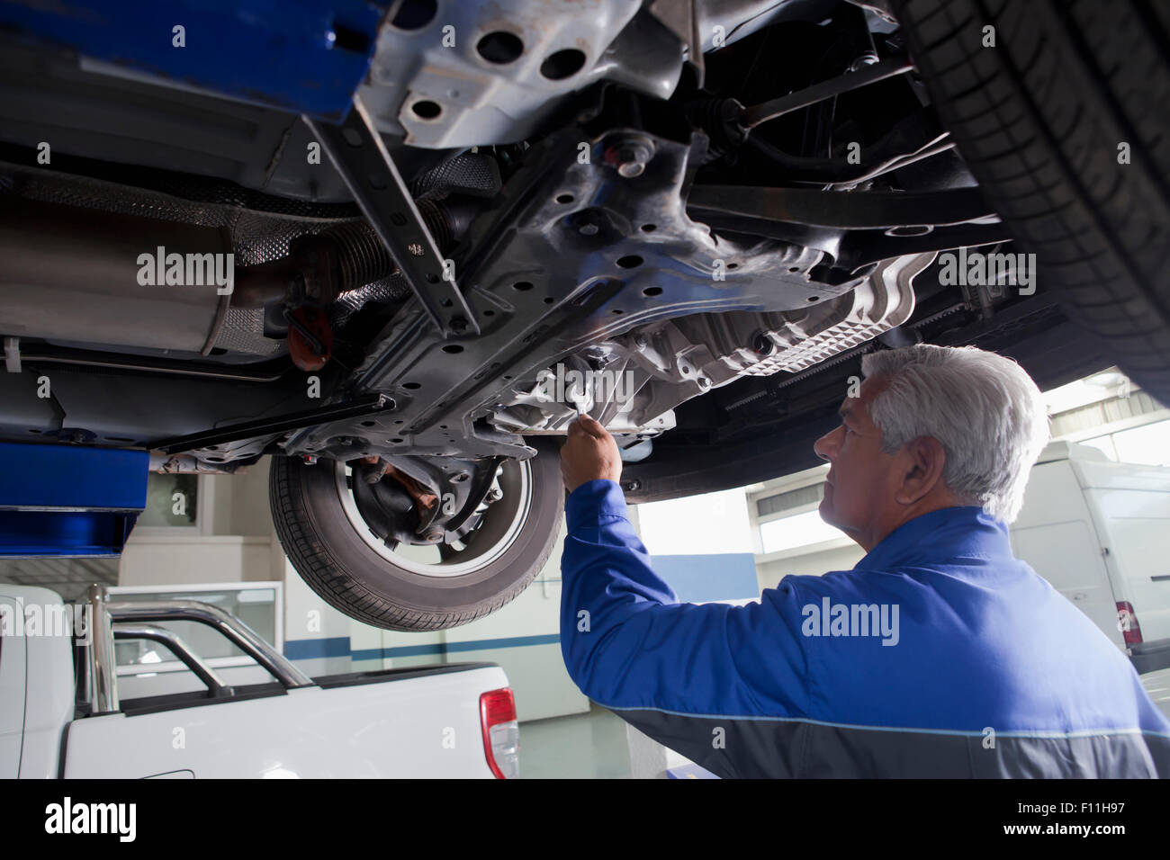 Older Hispanic mechanic repairing car in garage Stock Photo - Alamy